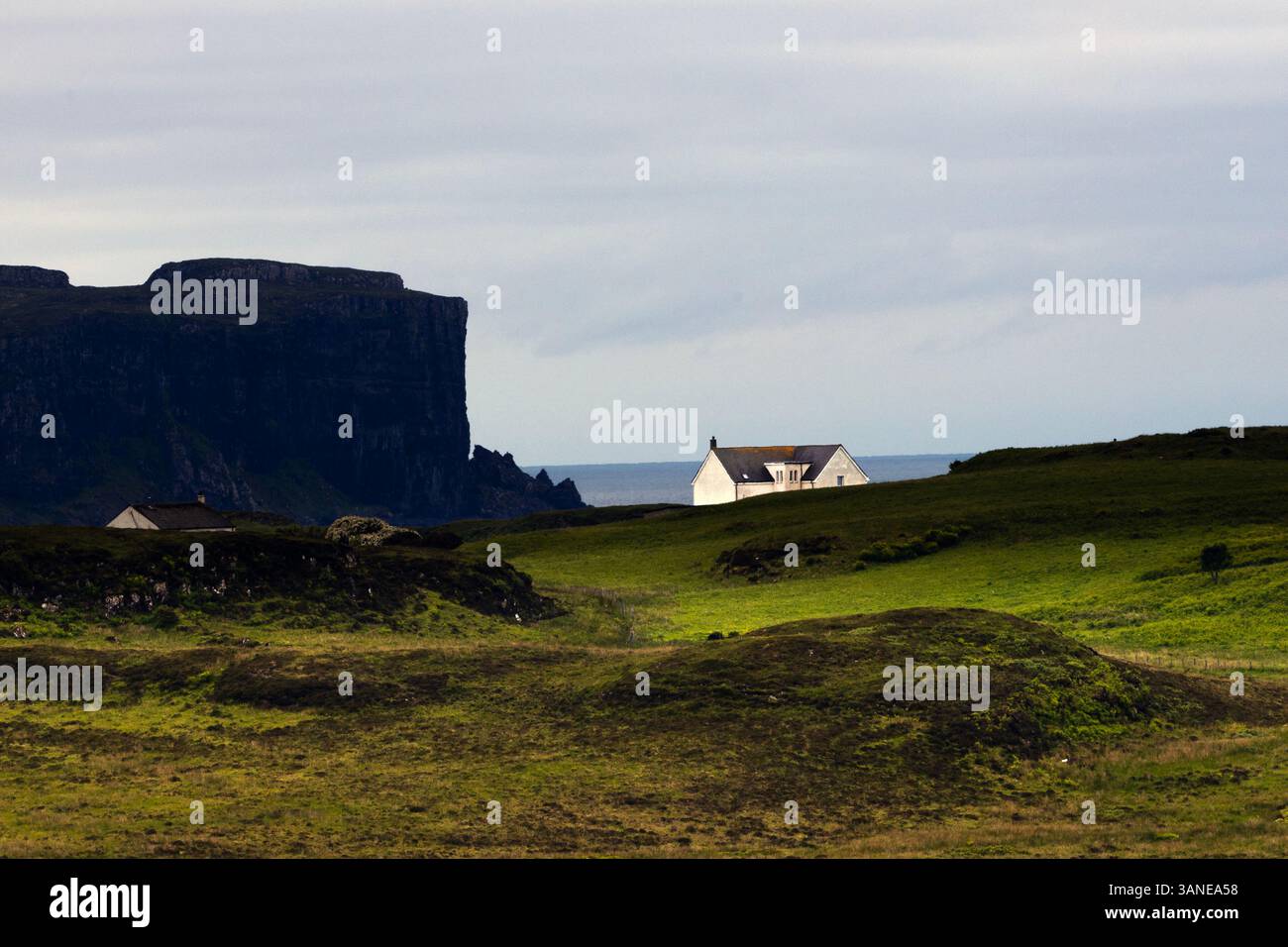 dark cliffs, dramatic skies, sea, white house, sunlit grass ...