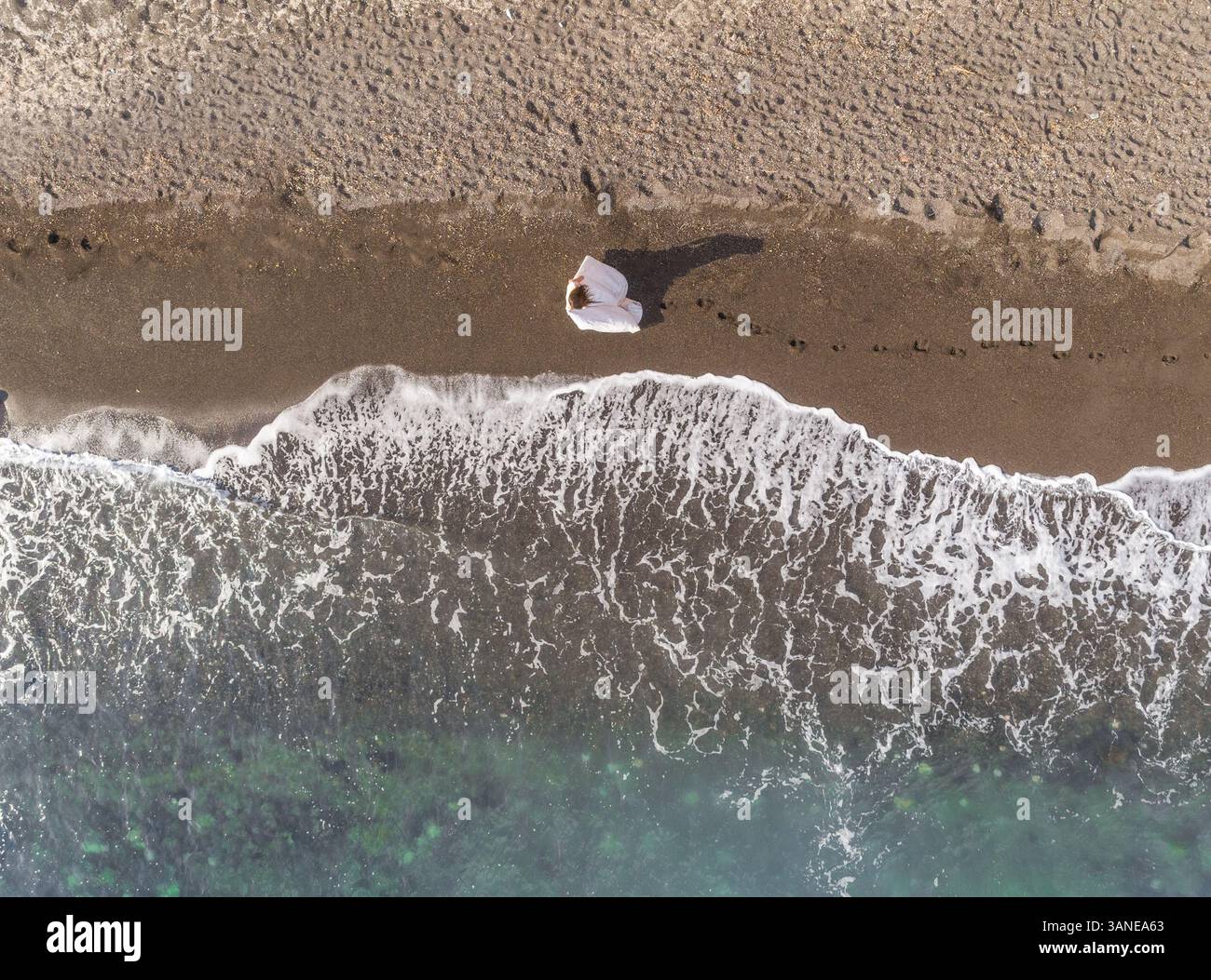 Aerial view of woman walking with wedding dress on beach Santorini ...