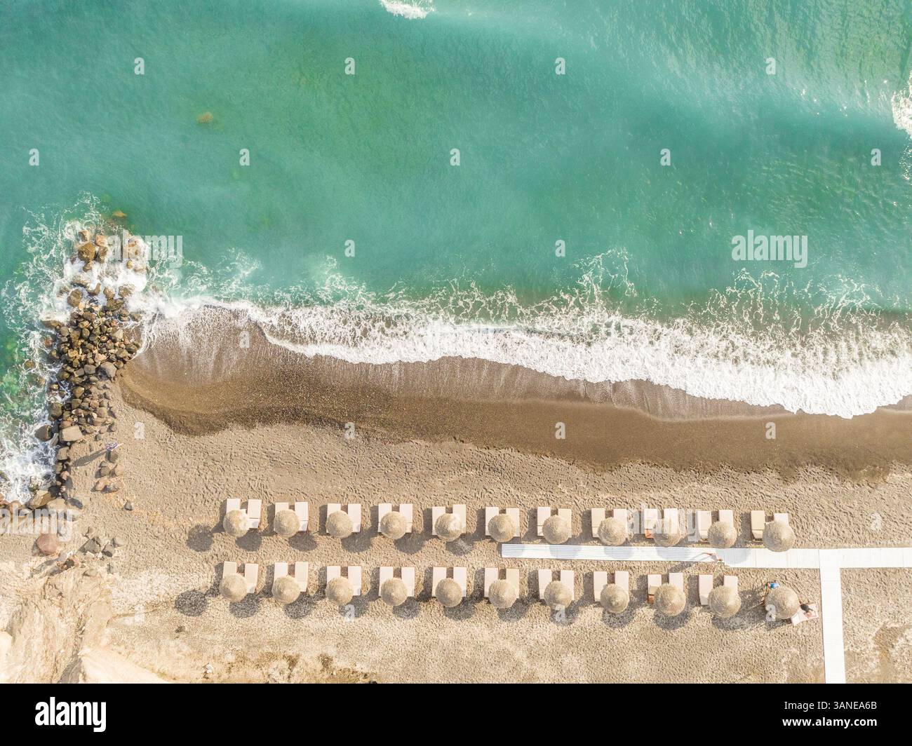 Aerial view of beach with thatch parasols on Santorini island, Greece ...