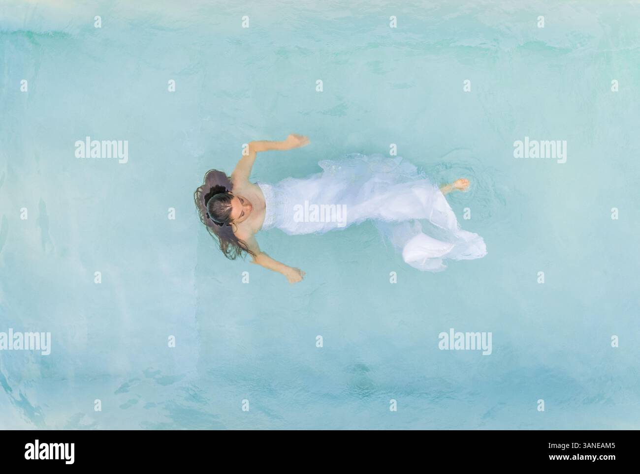 Aerial view above of a woman floating in water in a wedding dress Stock ...