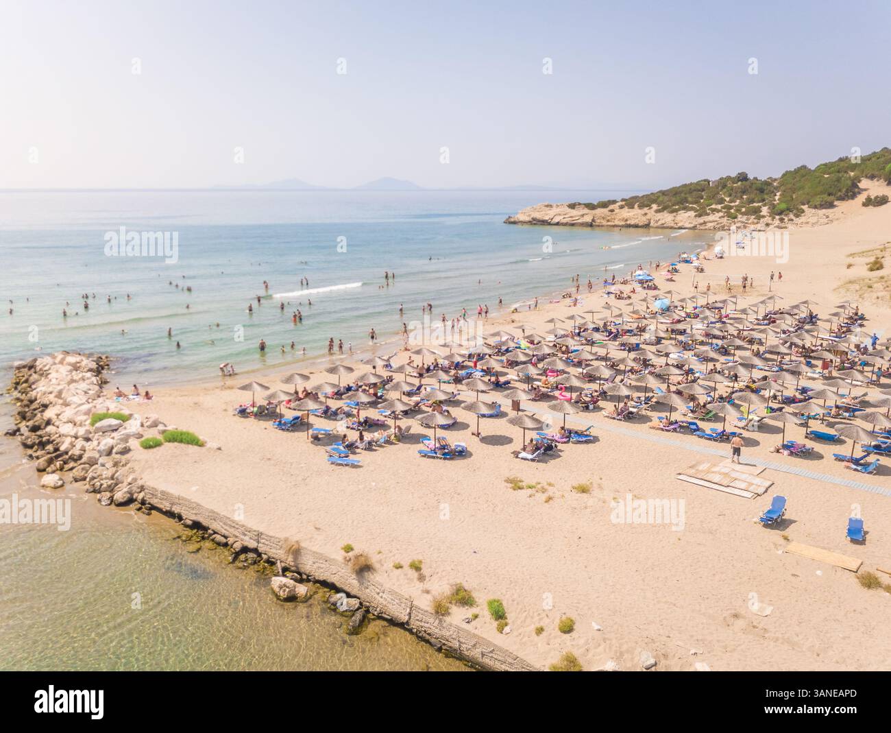 Aerial view of crowded beach with straw thatch parasols on Achaia ...