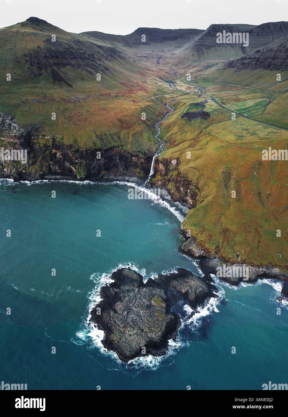 Aerial view of mountain waterfall Skarðsáfossur flowing into the ...