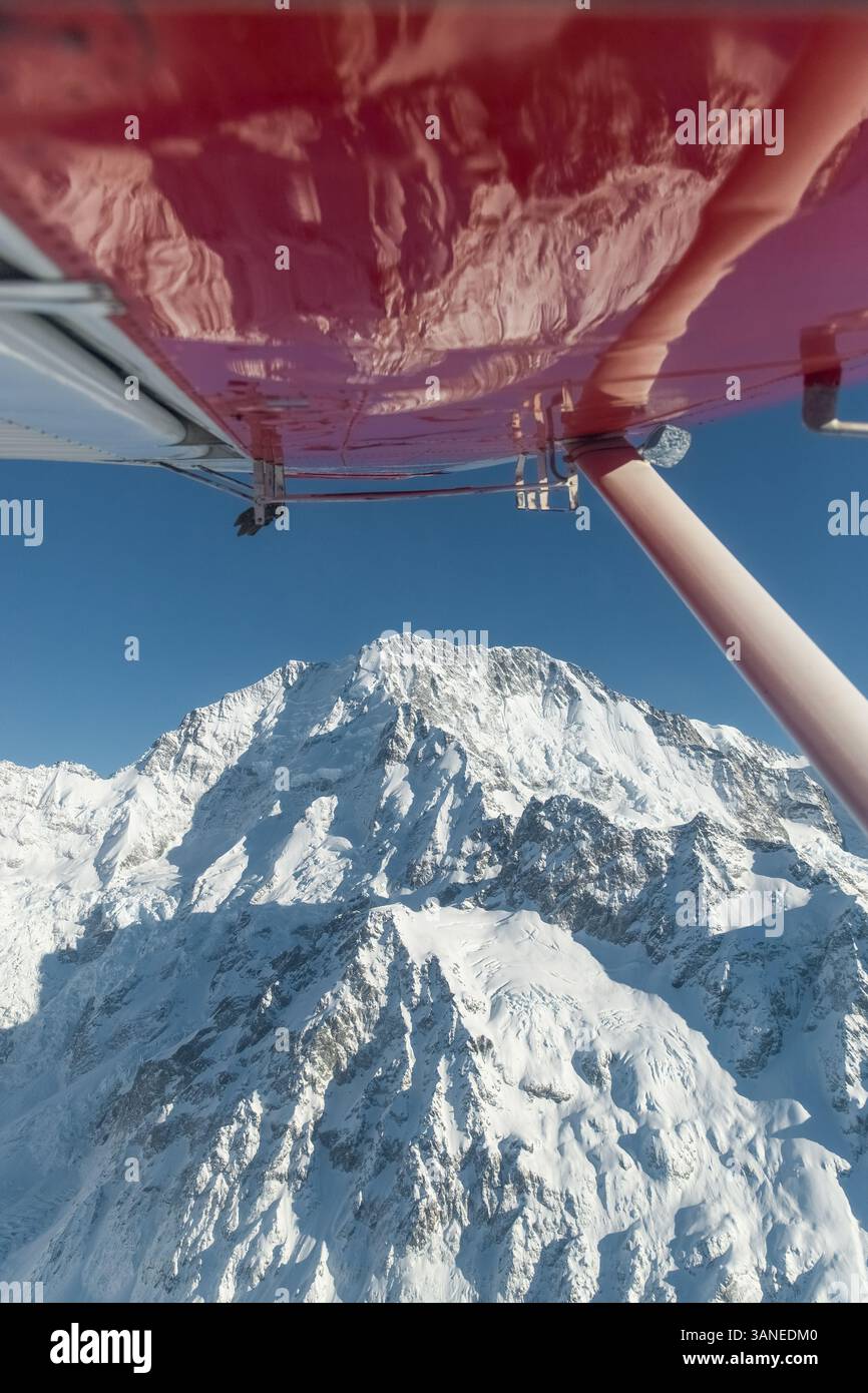 Aerial view from airplane window of snowy mountain peaks and glaciers ...