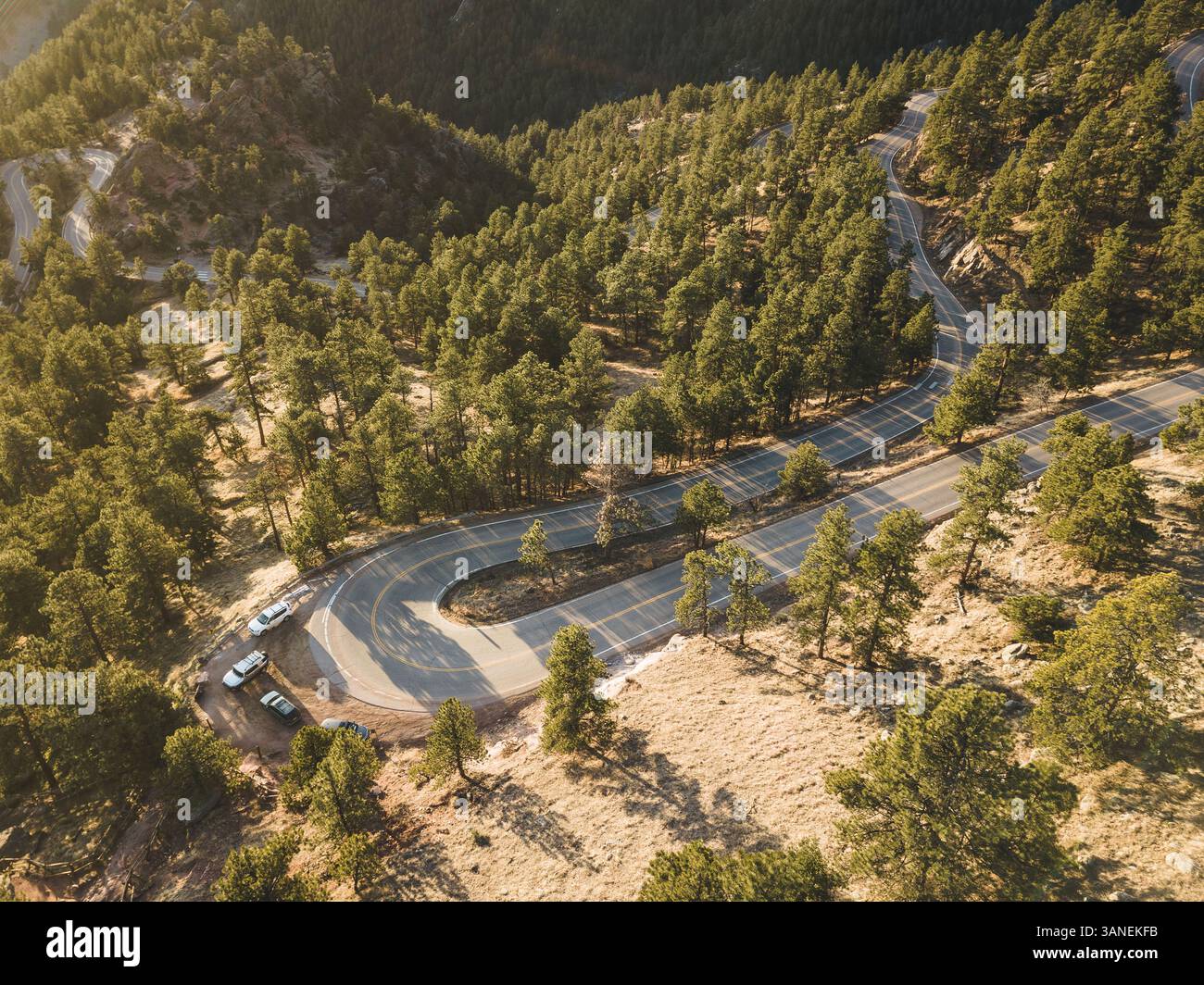 Aerial view of road in the forest on the mountain with a few vehicles ...