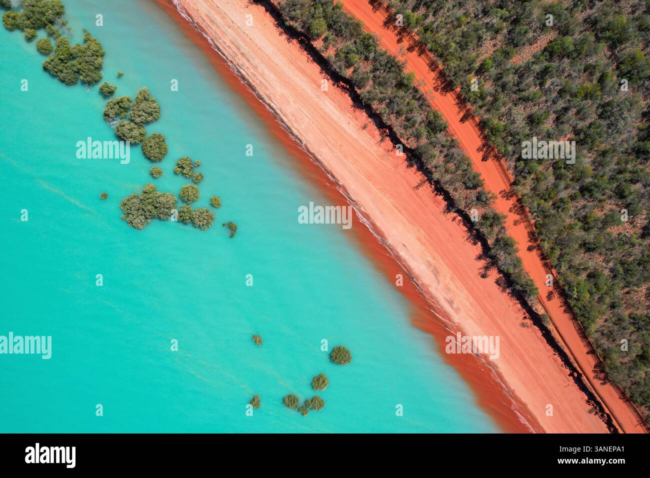 Aerial view of red sand beach and turquoise water along the coastline ...