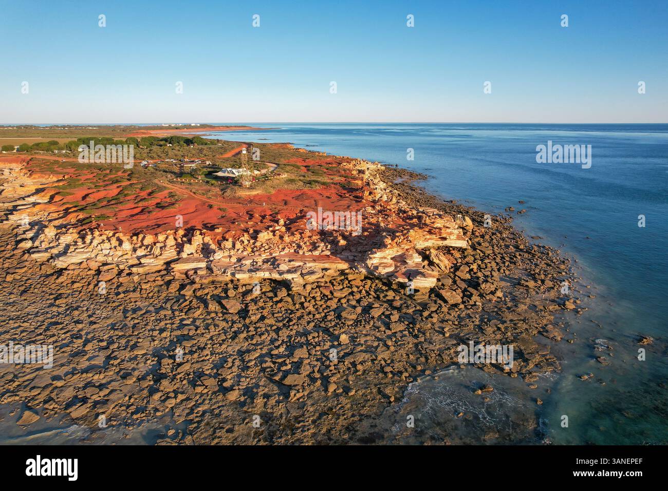 Aerial view of rugged coastline with red rocks and dinosaur footprints ...