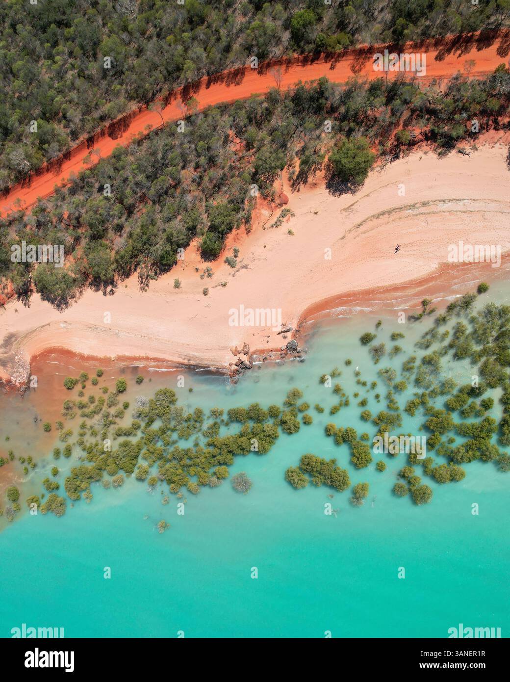 Aerial view of red sand beach with turquoise water and mangroves ...