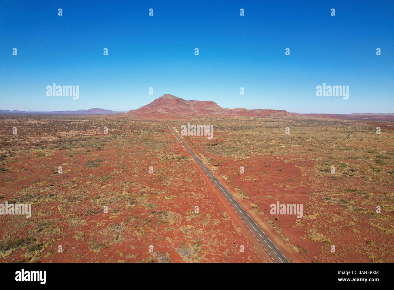 Aerial view of arid landscape with a winding road and rugged mountains ...