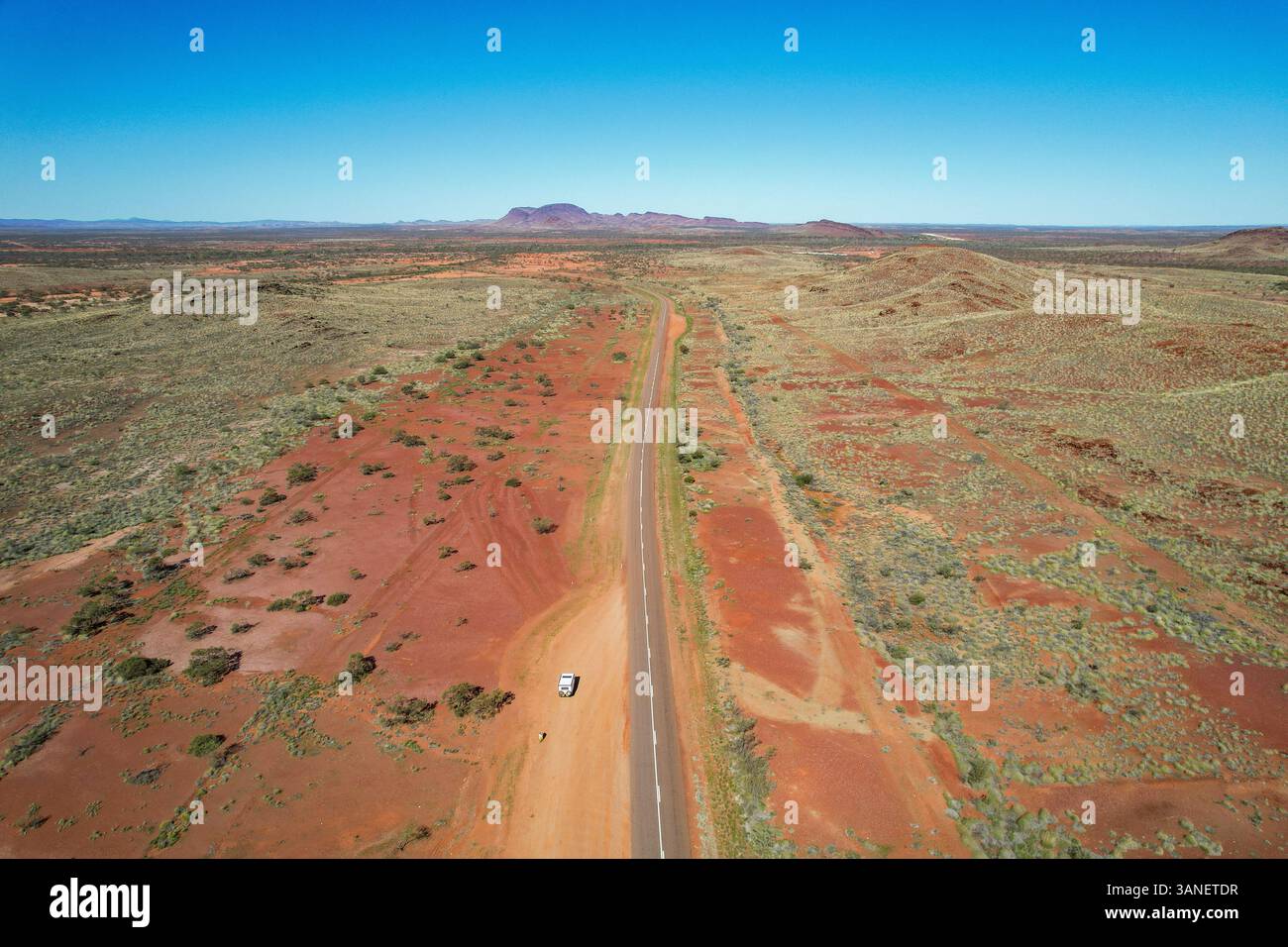 Aerial view of a remote desert landscape with a winding road and a ...