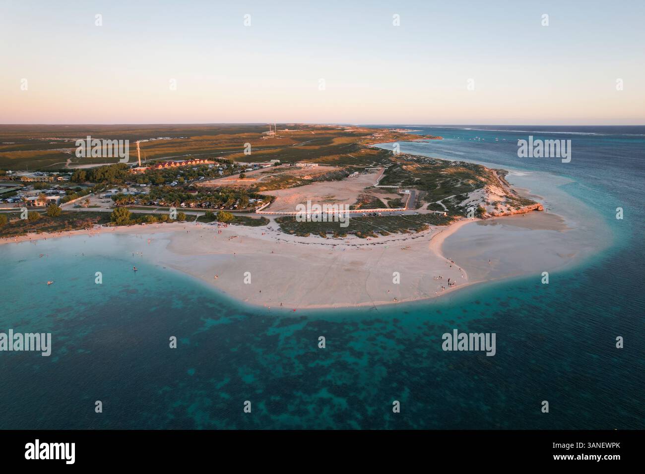 Aerial view of Bills Bay with beach goers and wind turbines near ...