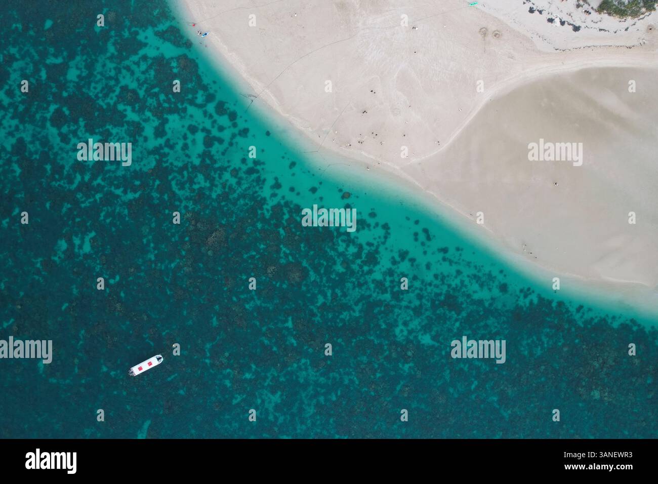 Aerial view of Bills Bay with beach goers and a reef boat, Coral Bay ...