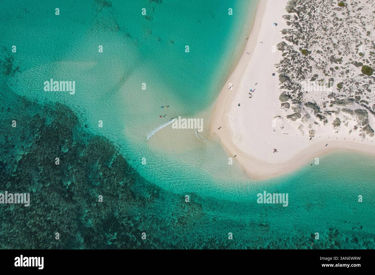 Aerial view of turquoise bay with beachgoers and sandy coastline ...