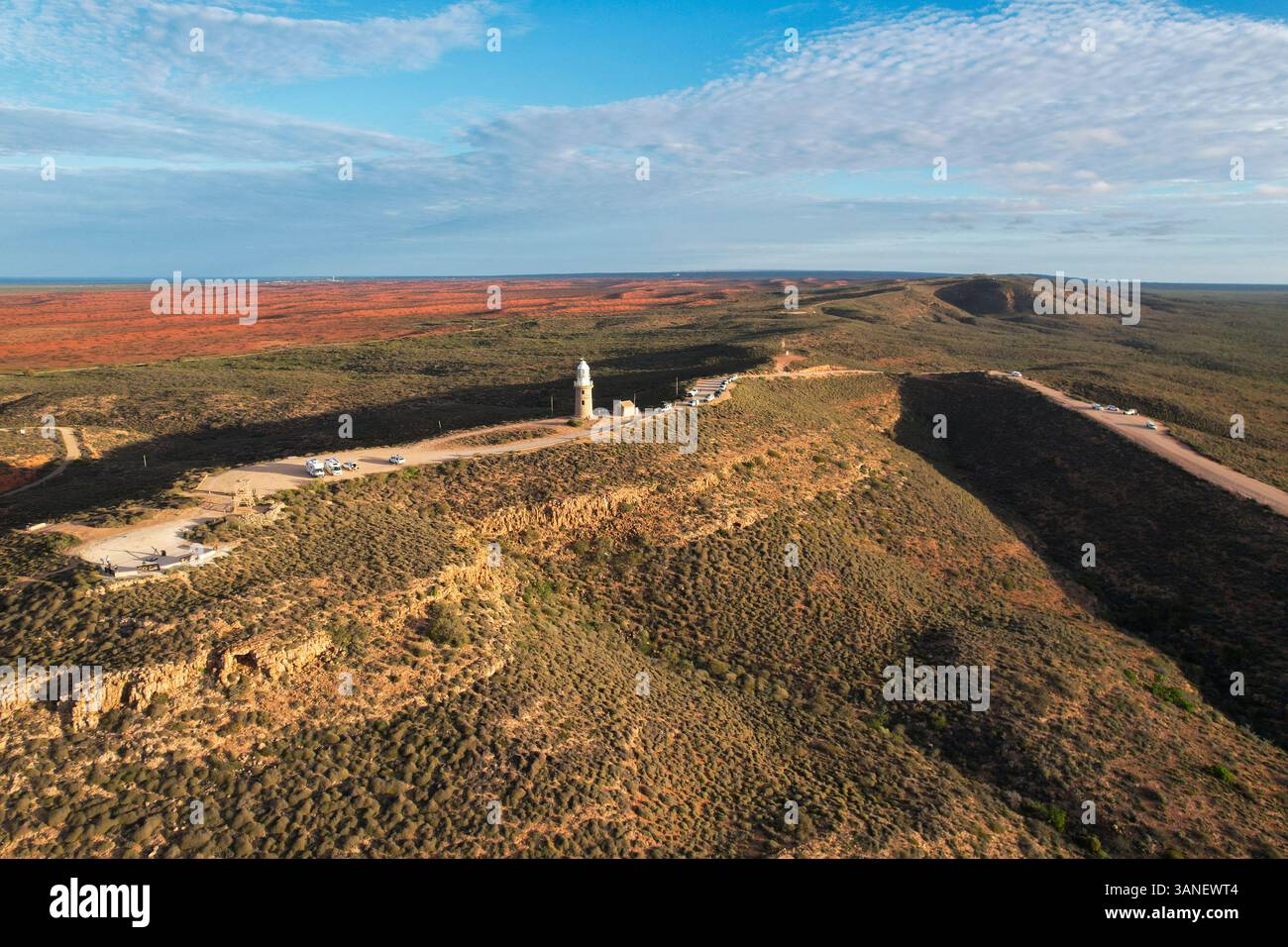 Aerial view of vlamingh head lighthouse and rugged landscape at sunset ...