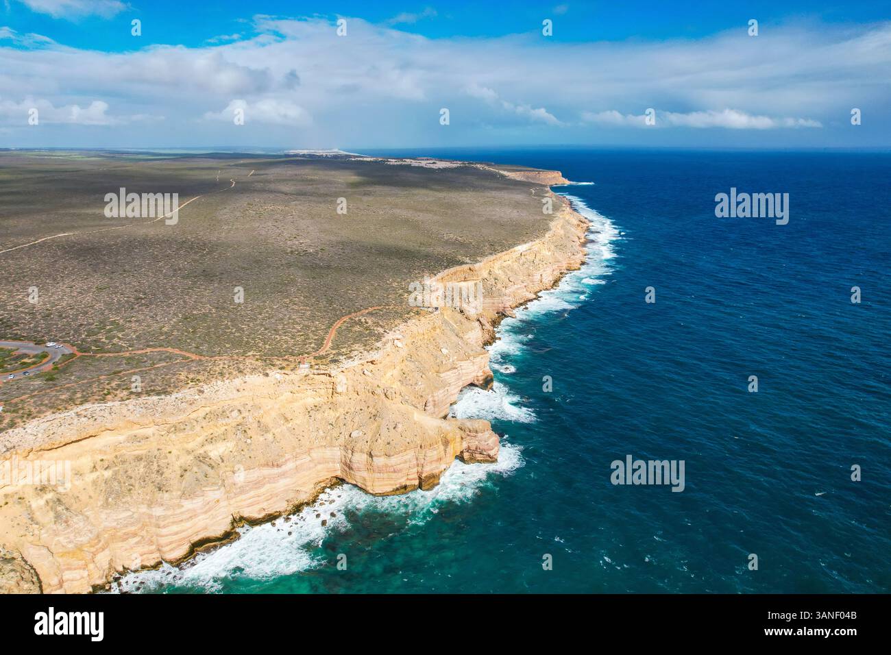 Aerial view of dramatic cliffs and serene ocean waves at Castle Cove ...
