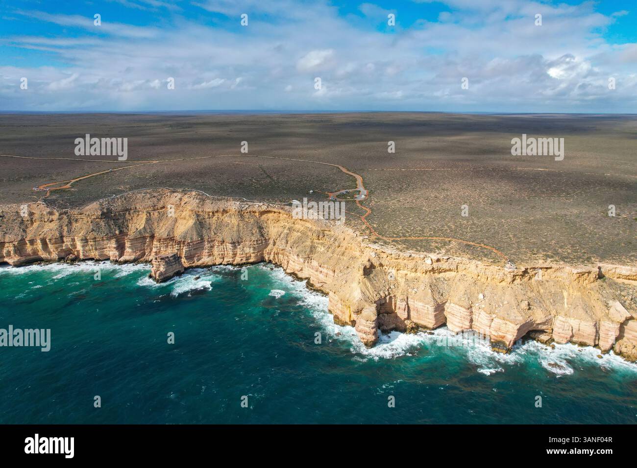 Aerial view of rugged cliffs and blue ocean waves at Castle Cove ...