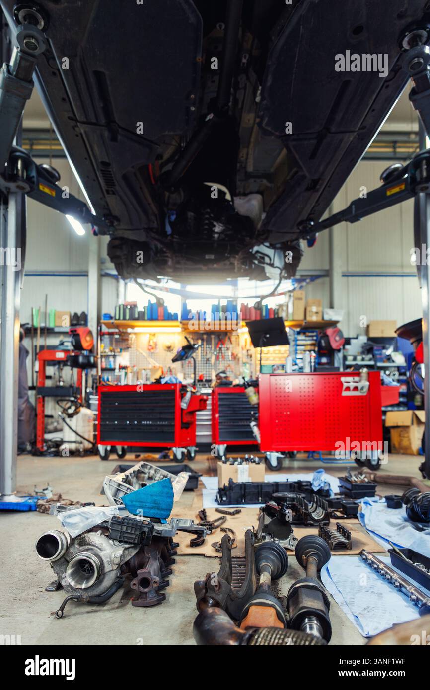 Scenic bottom POV disassembled SUV car with removed gearbox raised on ...