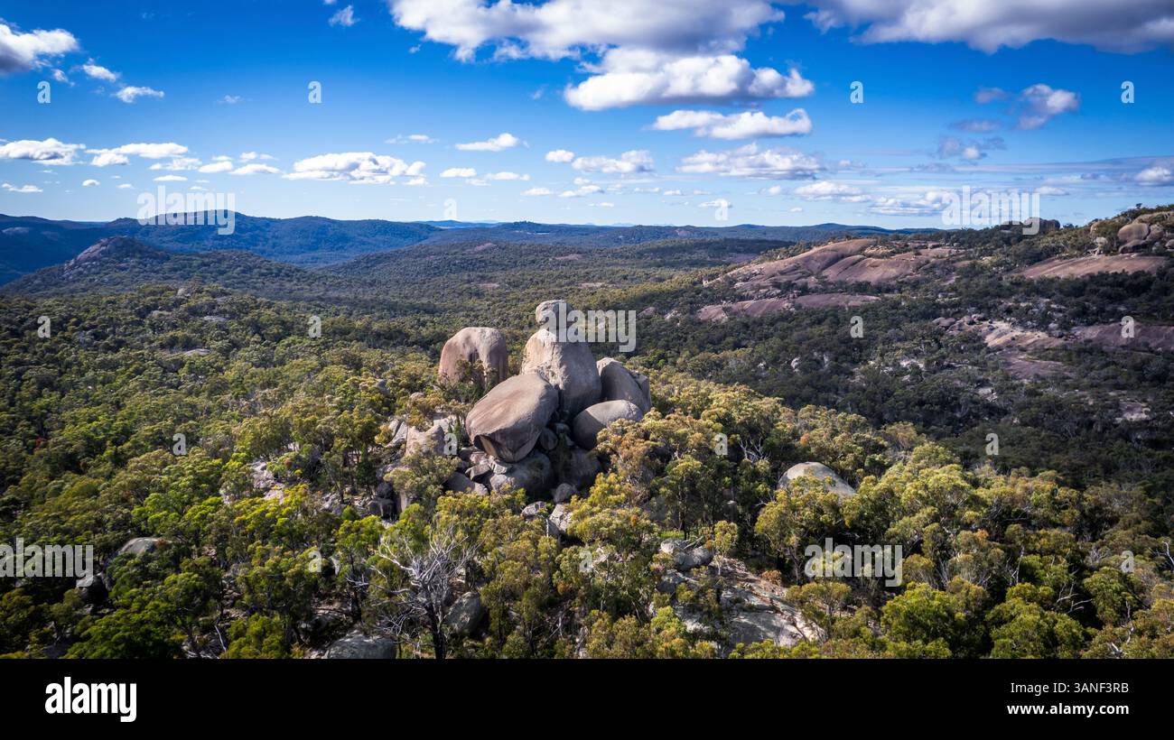 Aerial view of rock formations and forest under sky and clouds ...