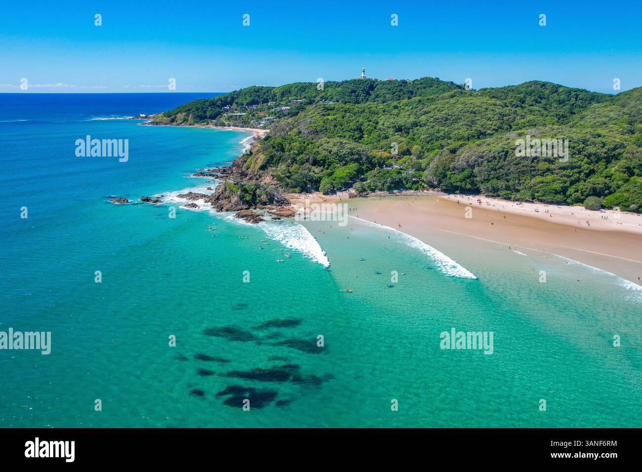 Aerial view of beautiful sandy beach with surfers at The Pass Beach ...
