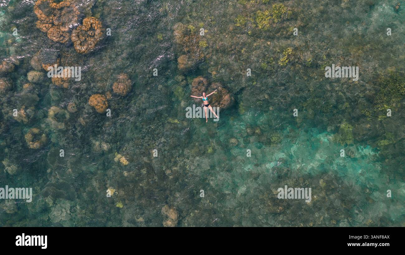 Aerial view of a woman floating on coral reef in Phillippines, Asia ...