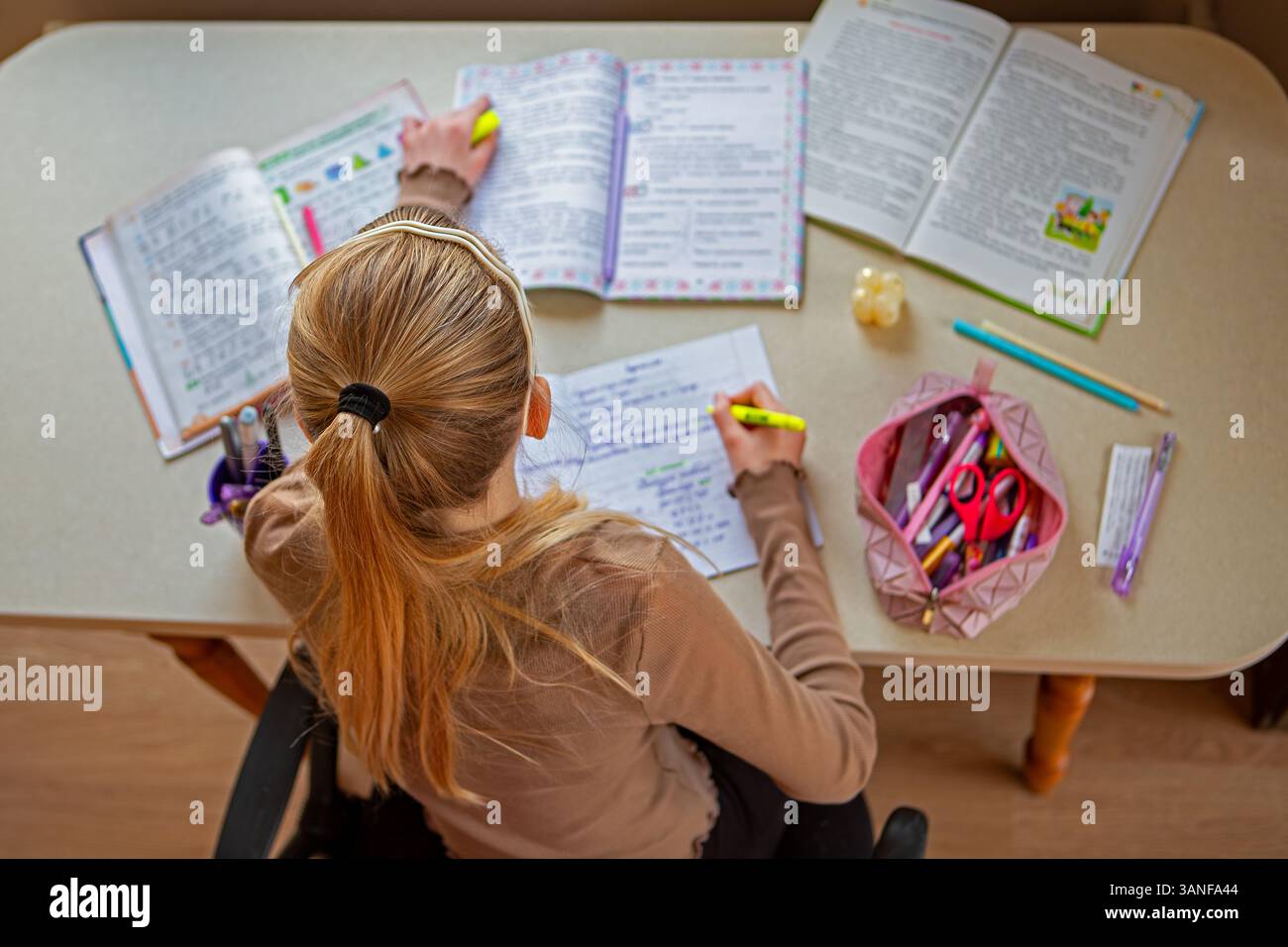 Schoolgirl highlighting notes while studying, A girl at a desk ...