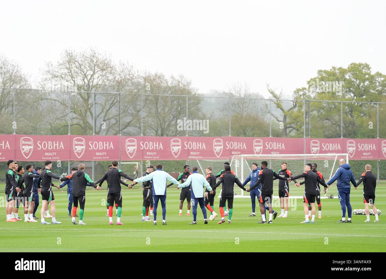 Arsenal players and staff form a circle during a training session at ...