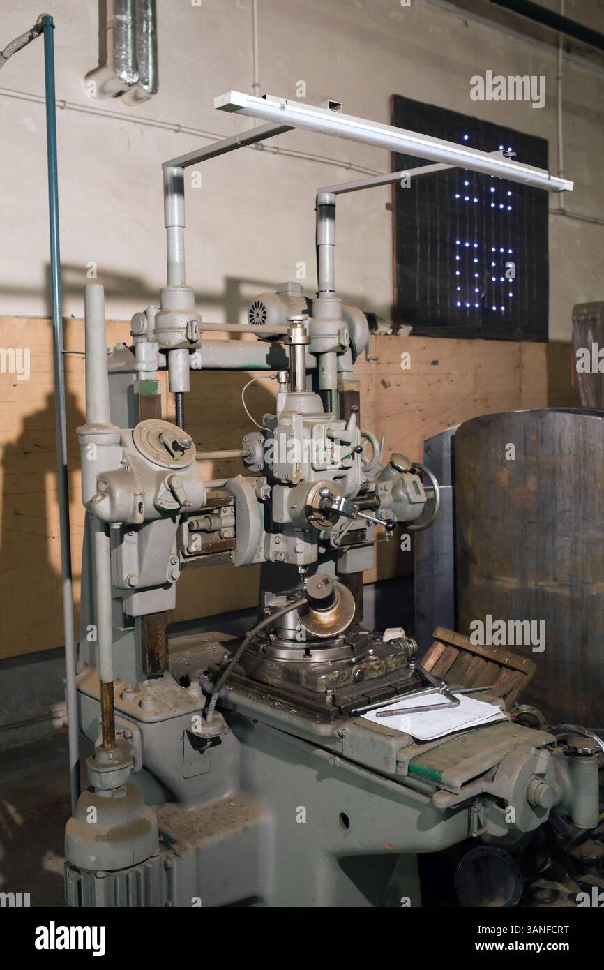 An old milling machine occupies the center of an industrial workshop ...