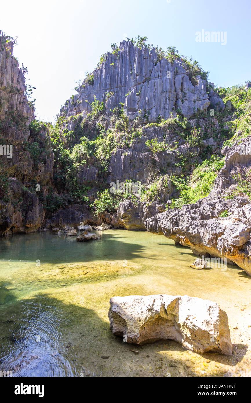Tangke Saltwater Lagoon surrounded by towering limestone cliffs, a ...