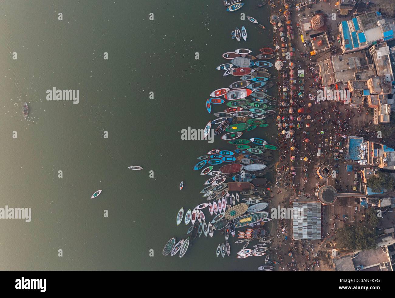 Aerial view of vibrant Ganges river with colorful boats and bustling ...