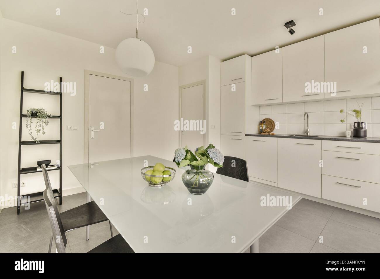 A sleek and minimalistic kitchen with a dining table, elegant lighting ...