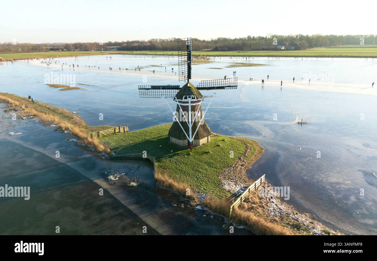 Aerial view of Ypey-Mole windmill with with ice skaters surrounded ...