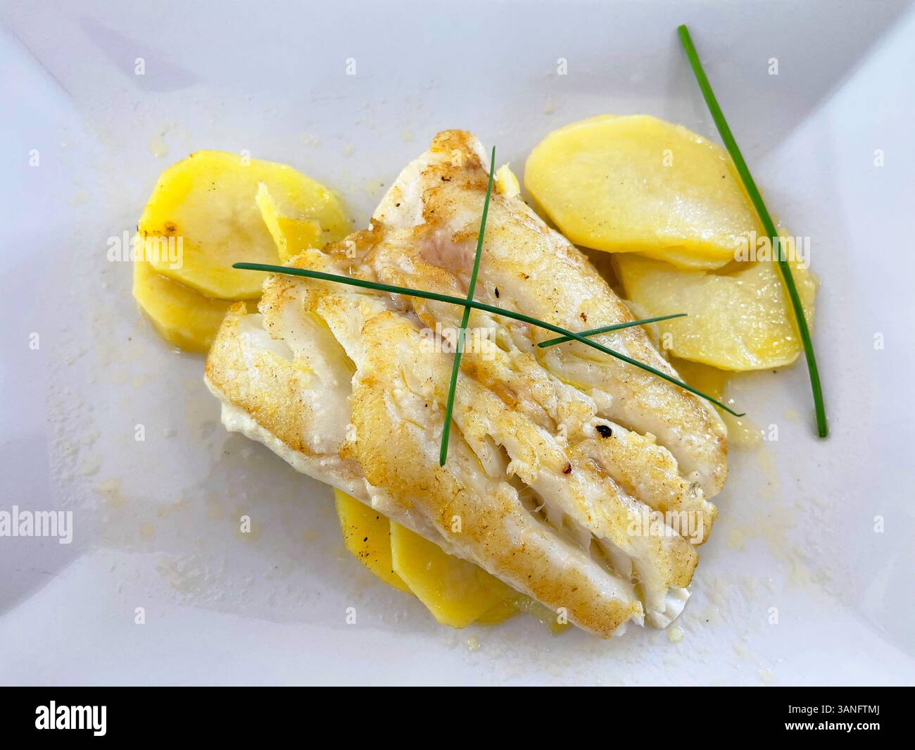 Grilled hake loin with potatoes and chives. Spain Stock Photo - Alamy