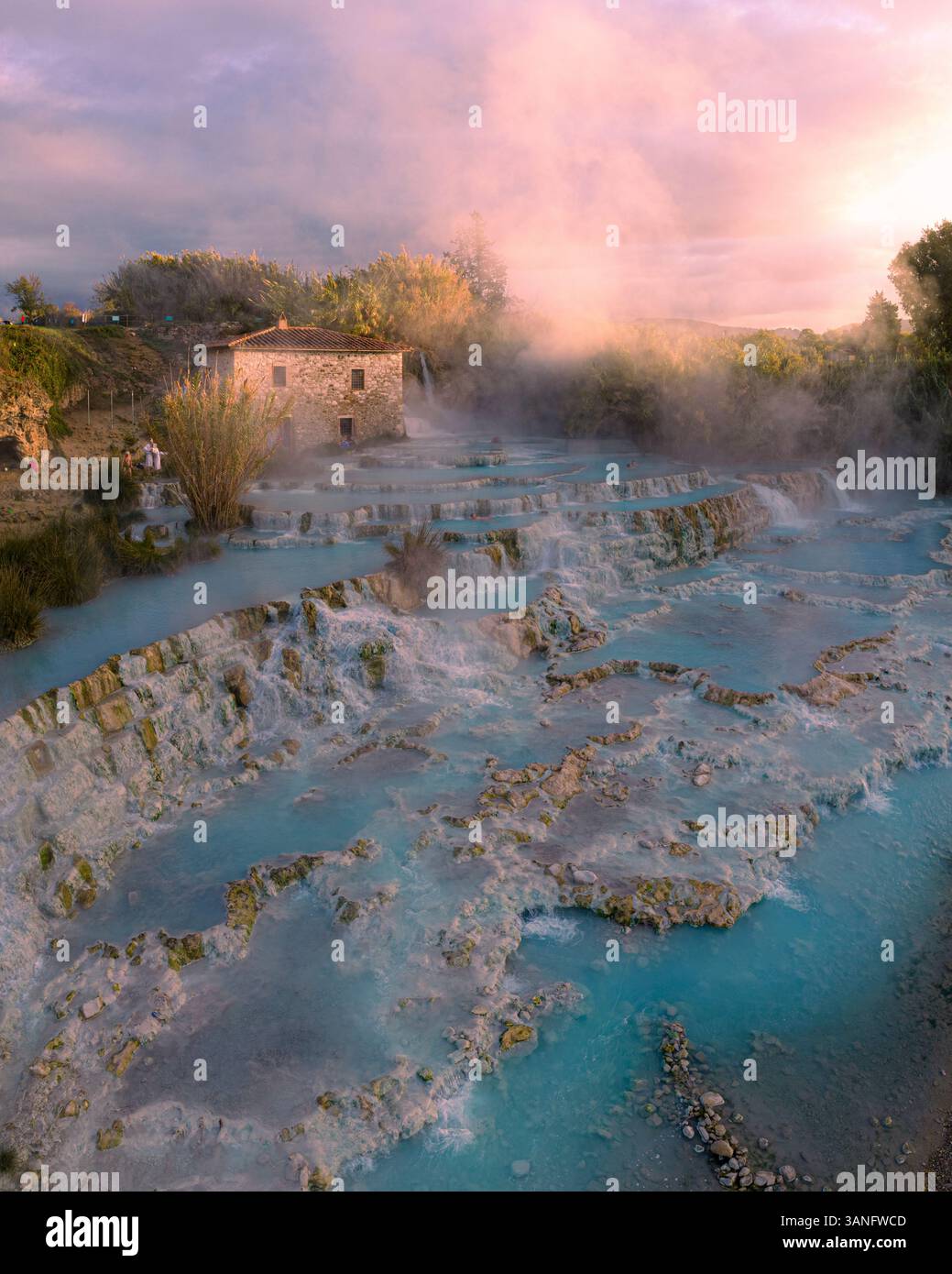 Aerial view of serene thermal pools with steam at sunrise in a ...