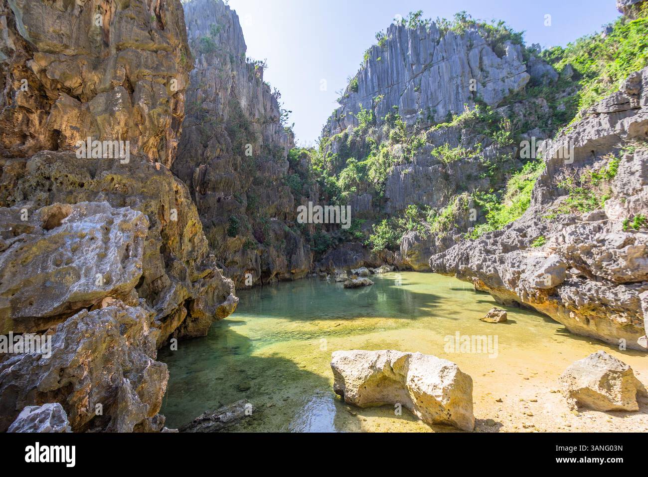 Tangke Saltwater Lagoon surrounded by towering limestone cliffs, a ...