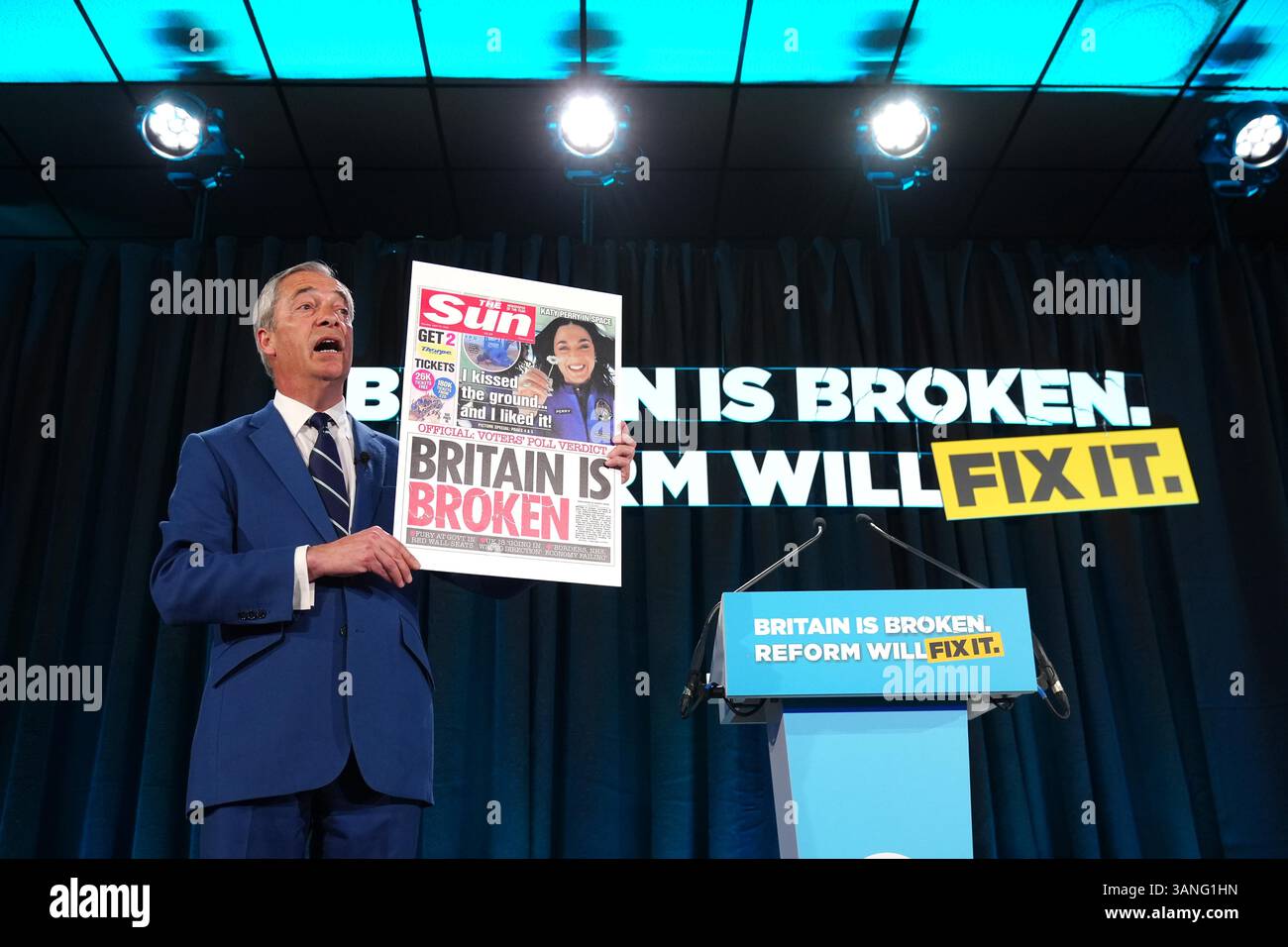 Reform UK leader Nigel Farage holds up a copy of the Sun newspaper as ...