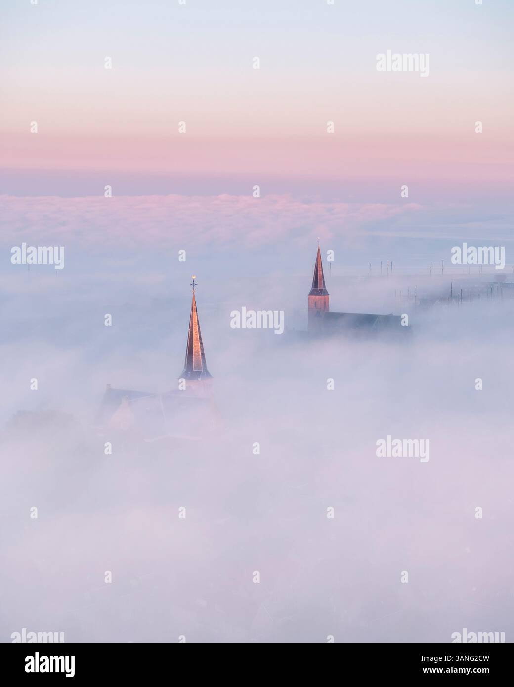 Aerial view of a peaceful city shrouded in fog with a majestic church ...