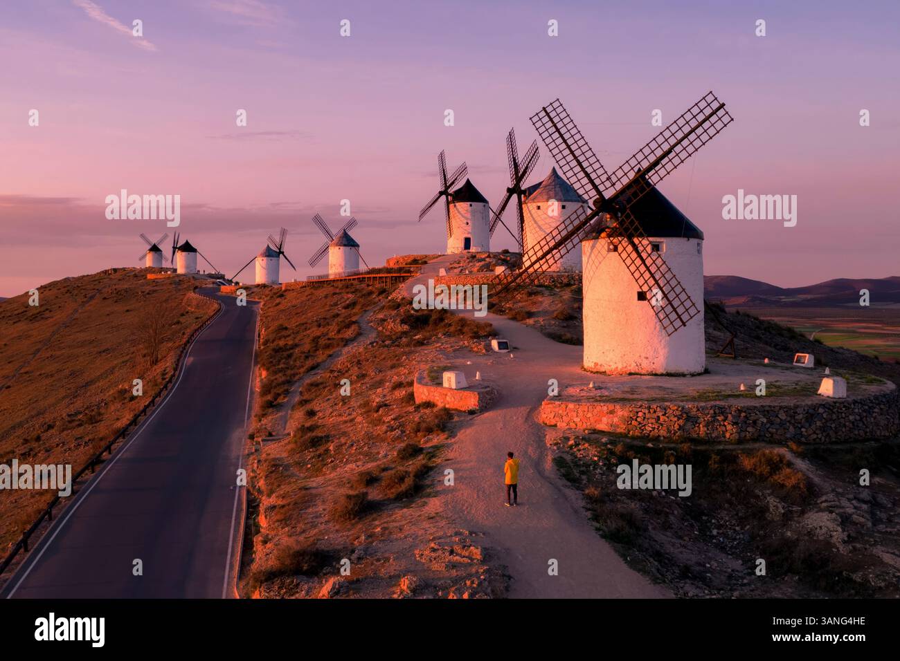 Aerial view of traditional windmills at sunrise with a scenic road ...