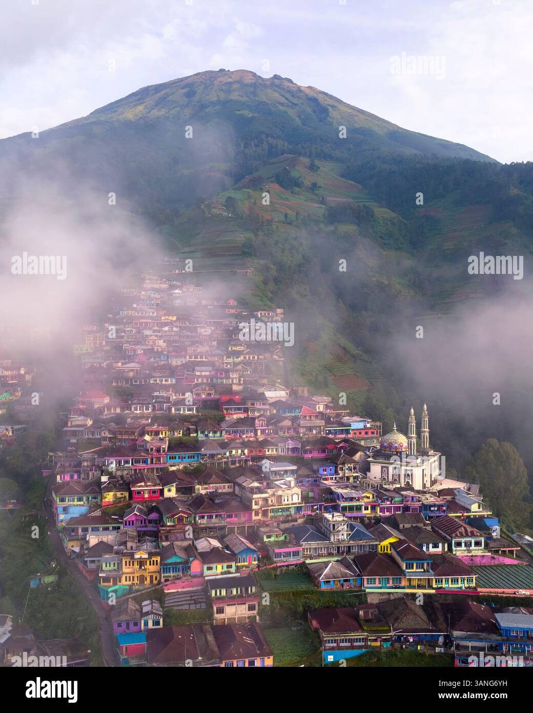 Aerial view of a colorful village with a majestic mosque and misty ...
