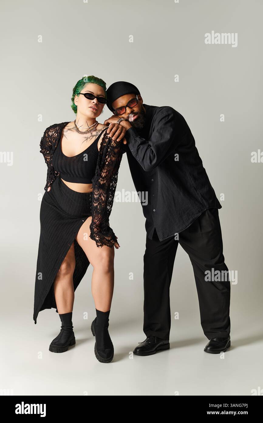 A young couple showcases their unique styles while posing confidently ...