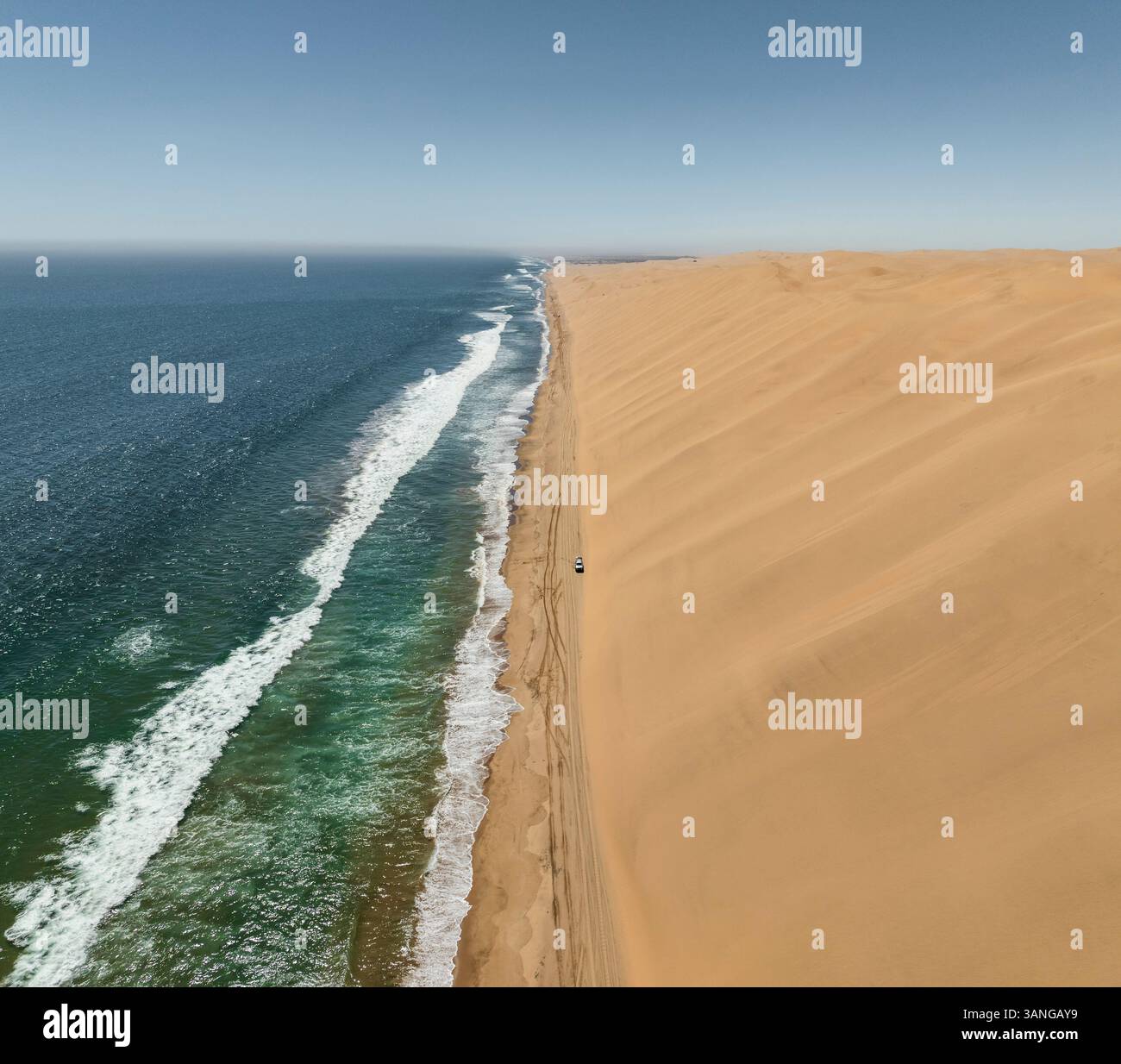 Aerial view of sandy coastline and blue ocean waves, Sandwich Harbour ...