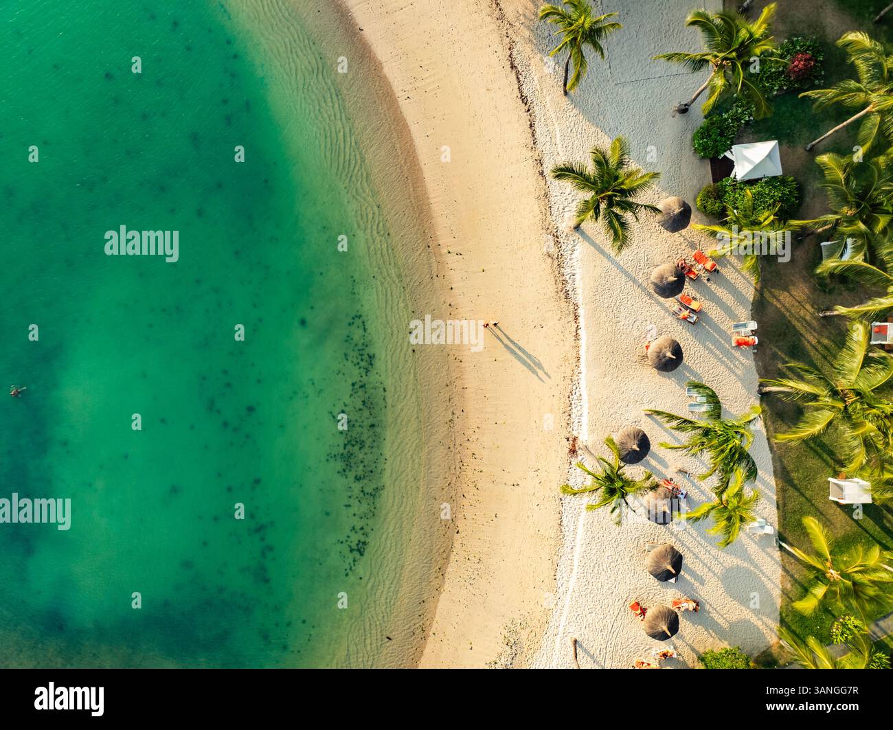 Aerial view of beach with turquoise water and people sunbathing ...