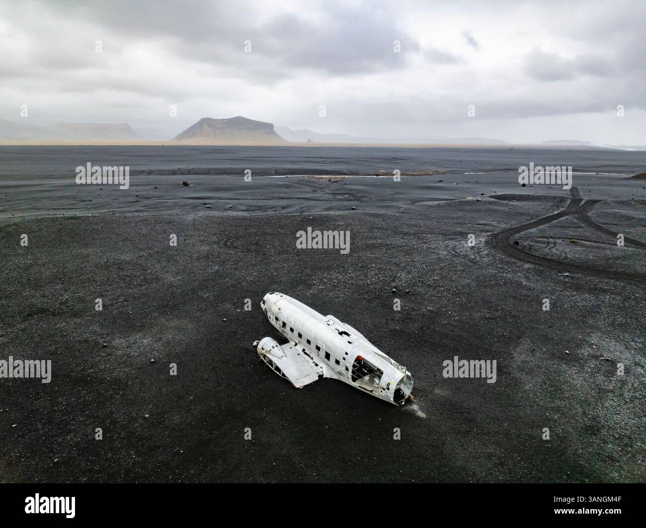 Aerial view of abandoned plane wreck on black sand beach ...