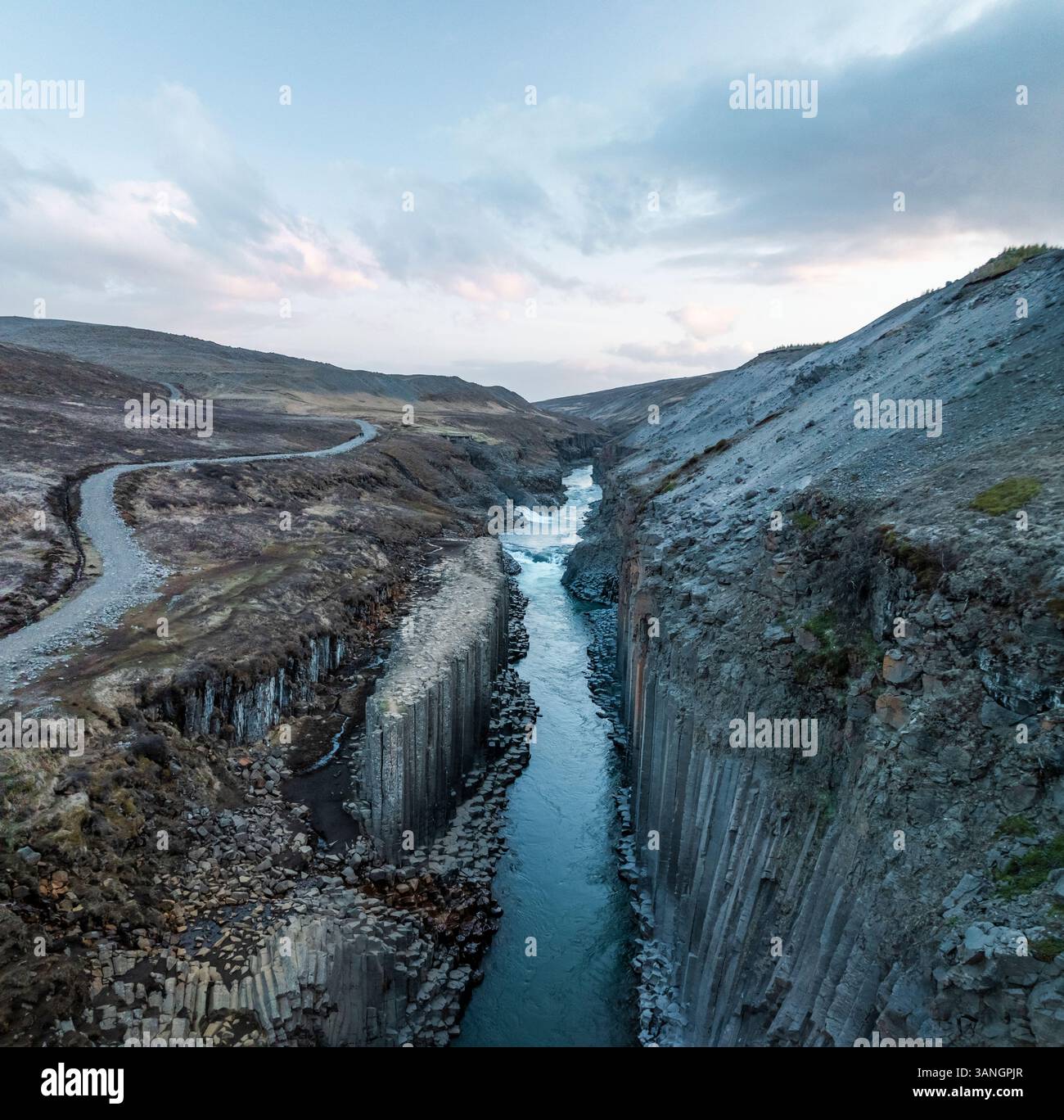 Aerial view of Studlagil canyon with blue water and basalt columns ...