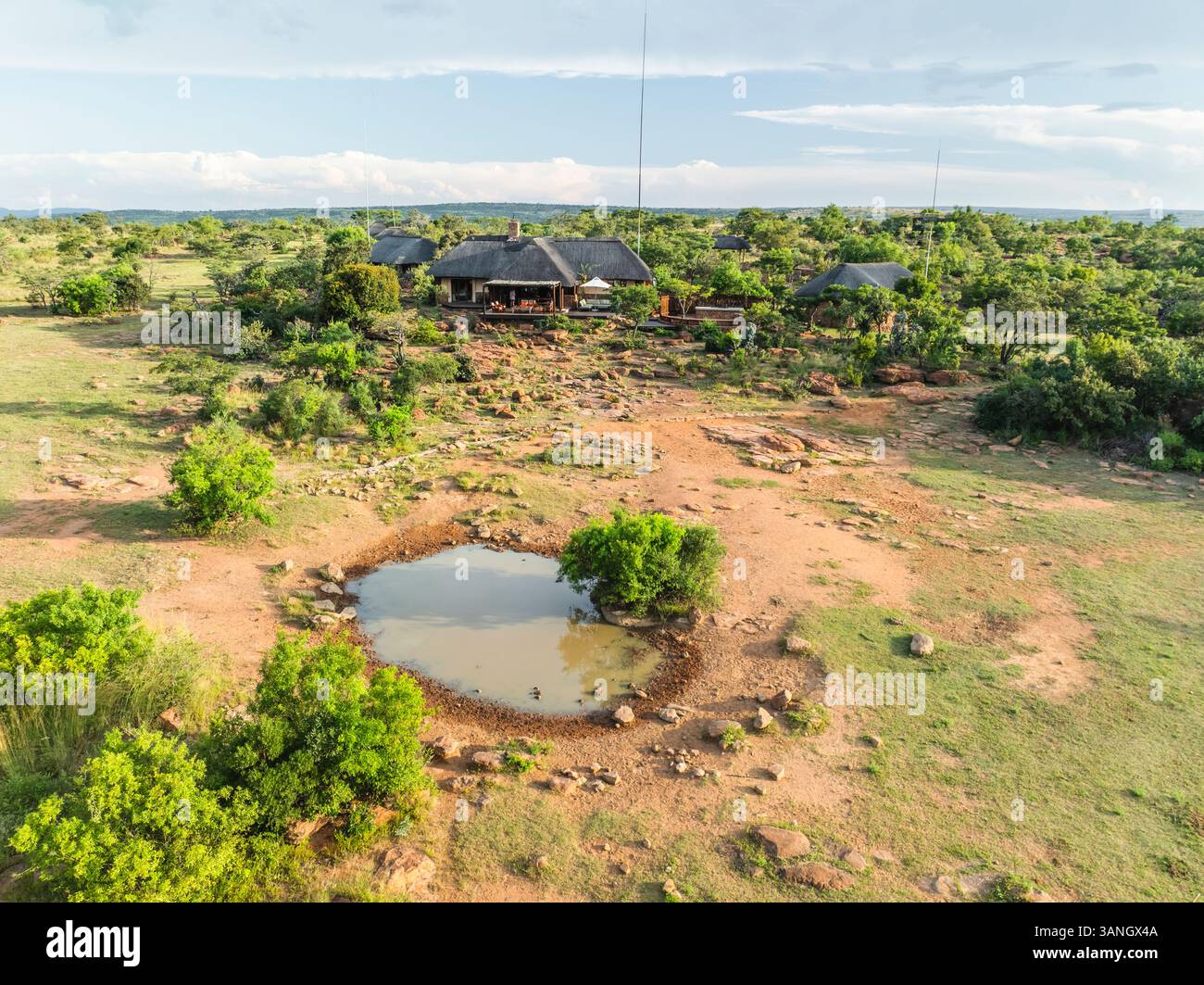 Aerial view of touristic houses with a small pond in the Savanna near ...
