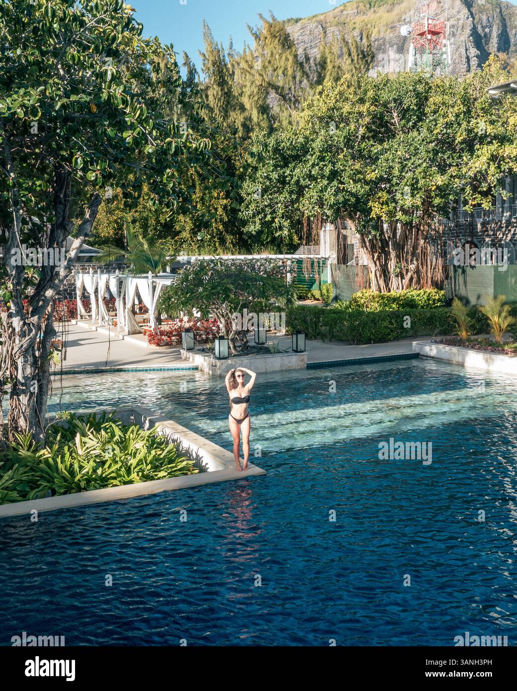 Aerial view of a woman along the swimming pool of luxury resort ...
