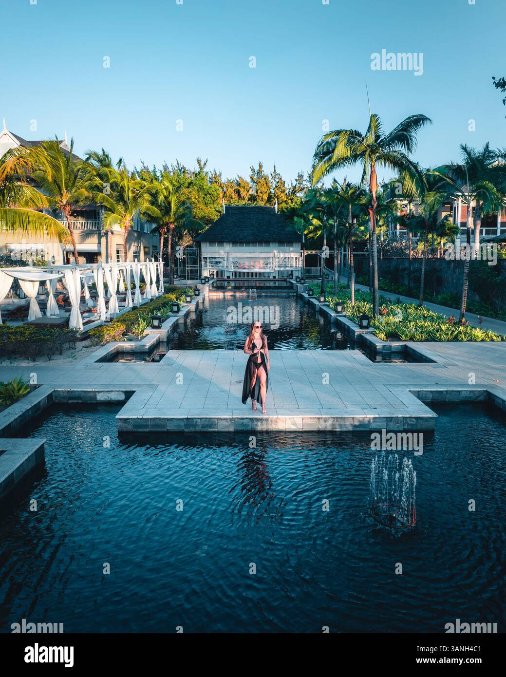 Aerial view of a woman along the swimming pool of luxury resort ...