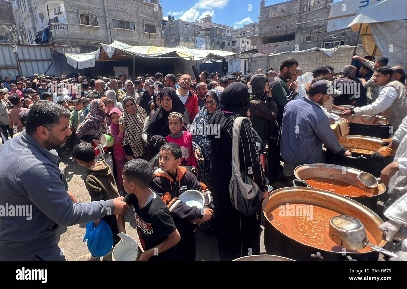 Palestinians gather in large numbers to receive the meals distributed ...
