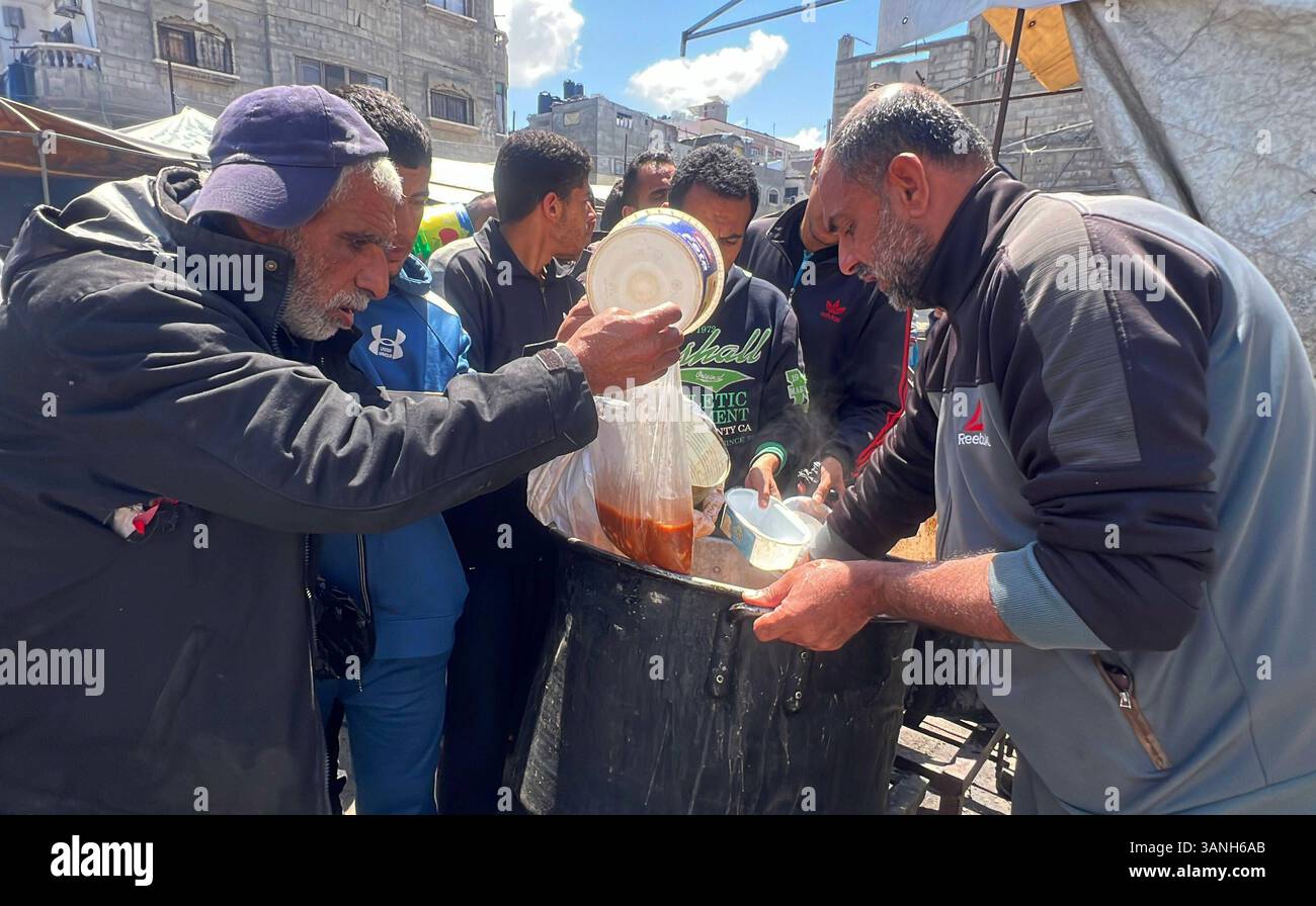 Palestinians gather in large numbers to receive the meals distributed ...