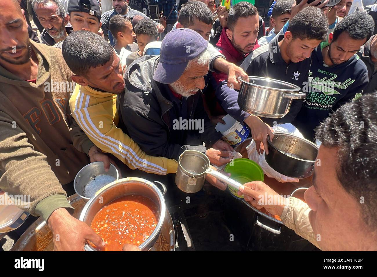 Palestinians gather in large numbers to receive the meals distributed ...
