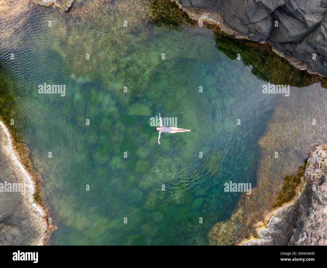 Aerial view of a woman swimming at Mosteiros Rock Pool, Piscinas ...
