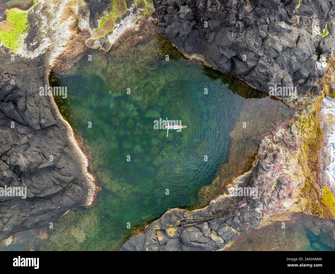 Aerial view of a woman swimming at Mosteiros Rock Pool, Piscinas ...